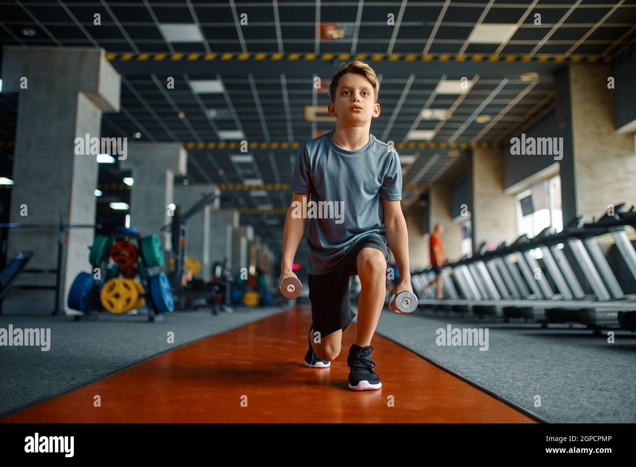 Boy doing exercise with dumbbells in gym. Youngster on training in ...