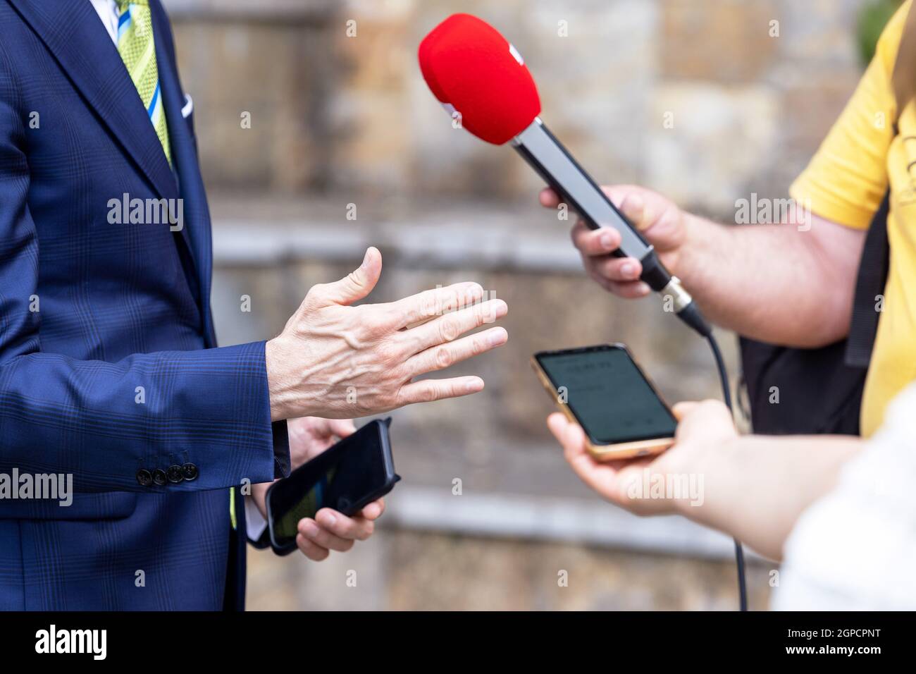 Reporter holding microphone making media interview with politician or business person Stock ...