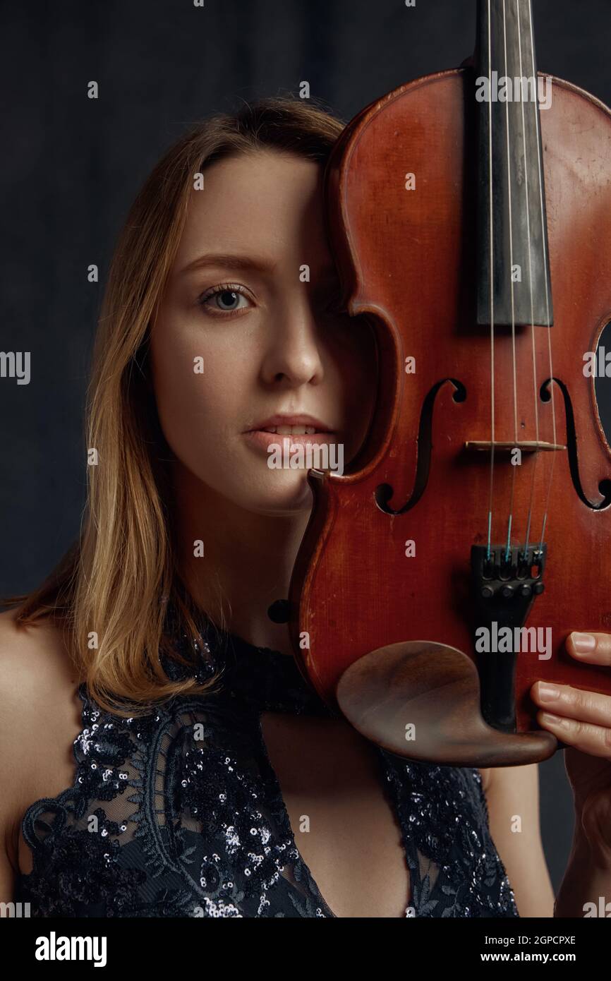 Female violonist with retro violin at her face. Woman with string ...