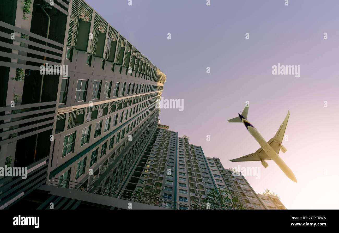 Airplane flying above modern apartment building. Exterior facade of ...