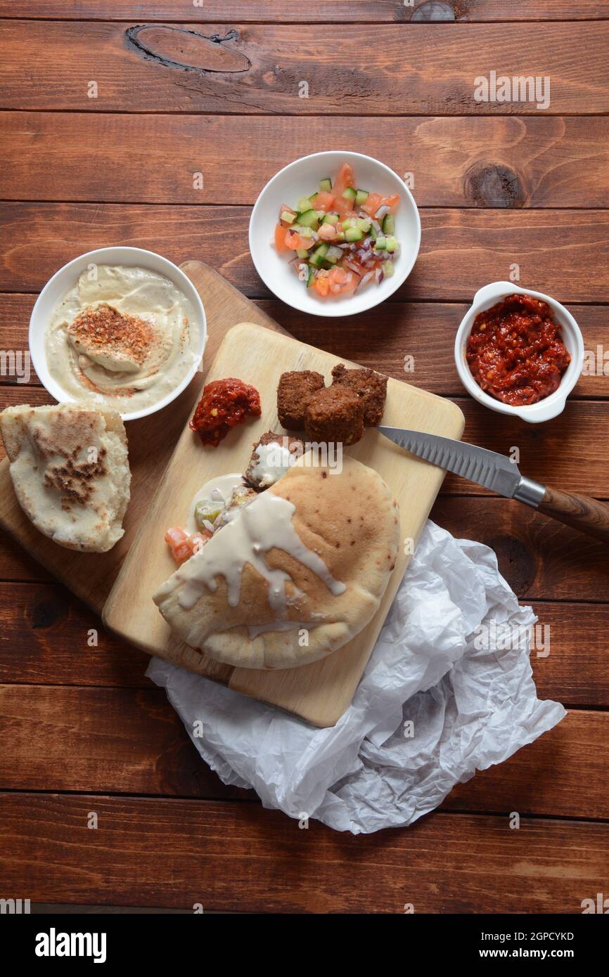 Falafel in pita bread with vegetable salad, harissa sauce, humus ...