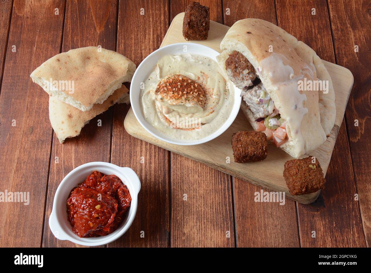 Falafel in pita bread with vegetable salad, harissa sauce, humus ...