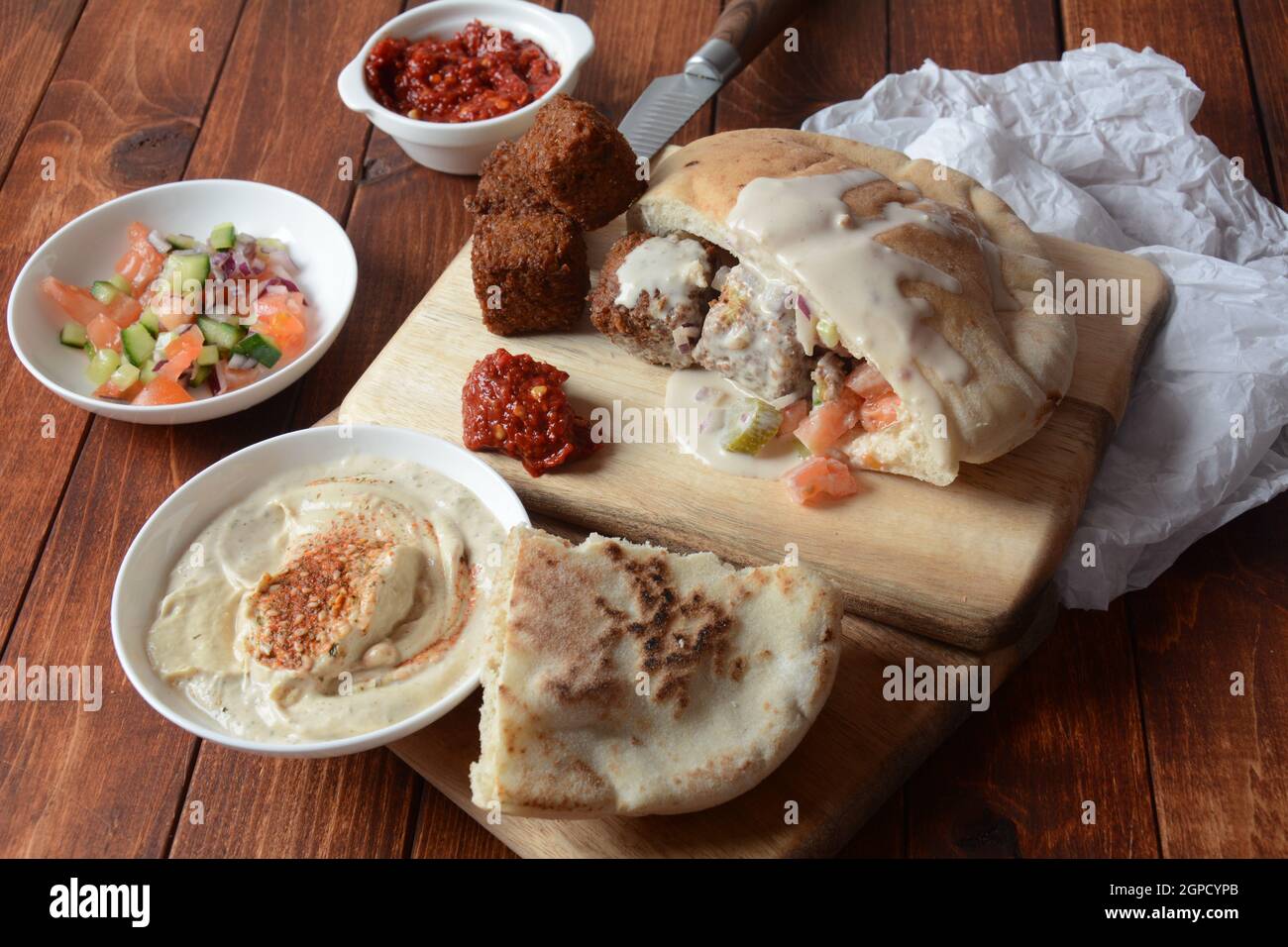 Falafel in pita bread with vegetable salad, harissa sauce, humus ...