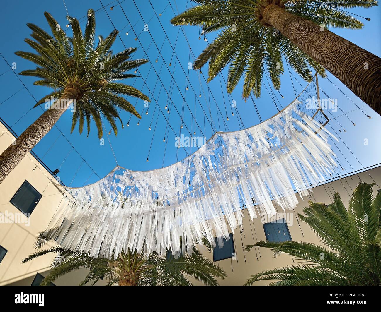 Street art made of delicate fabrics cut into strips between the houses ...