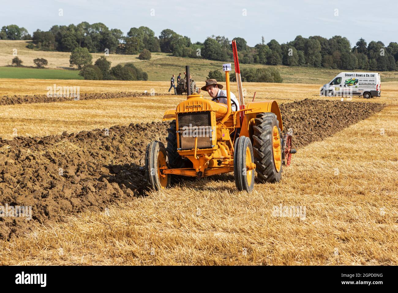 A classic old yellow Fordson tractor ploughing at a competition Stock ...