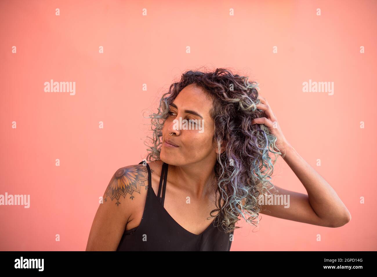 Woman shot against peach colored wall Stock Photo - Alamy