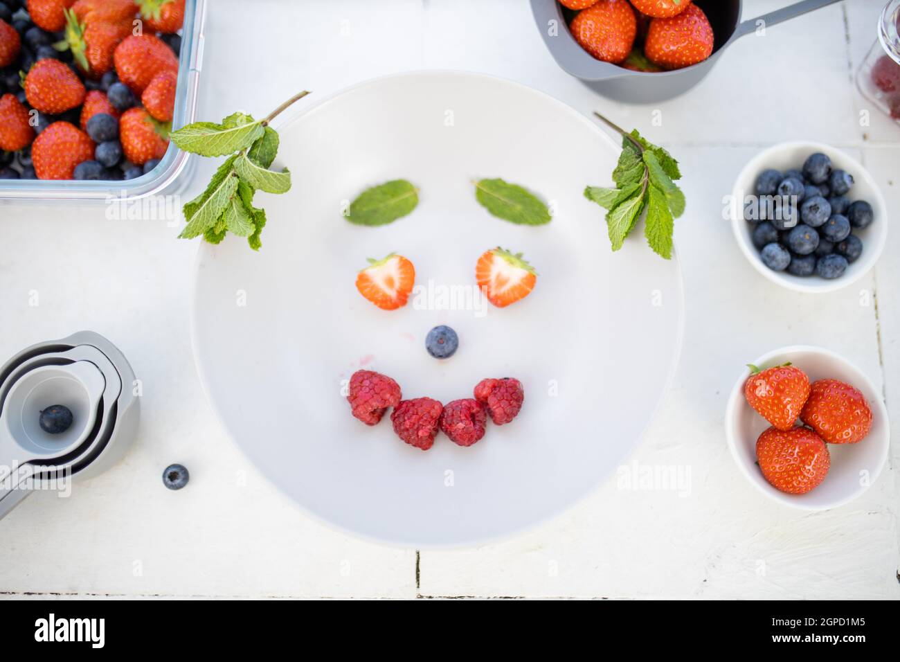 Funny smiling face made with strawberries, blueberries, raspberries ...