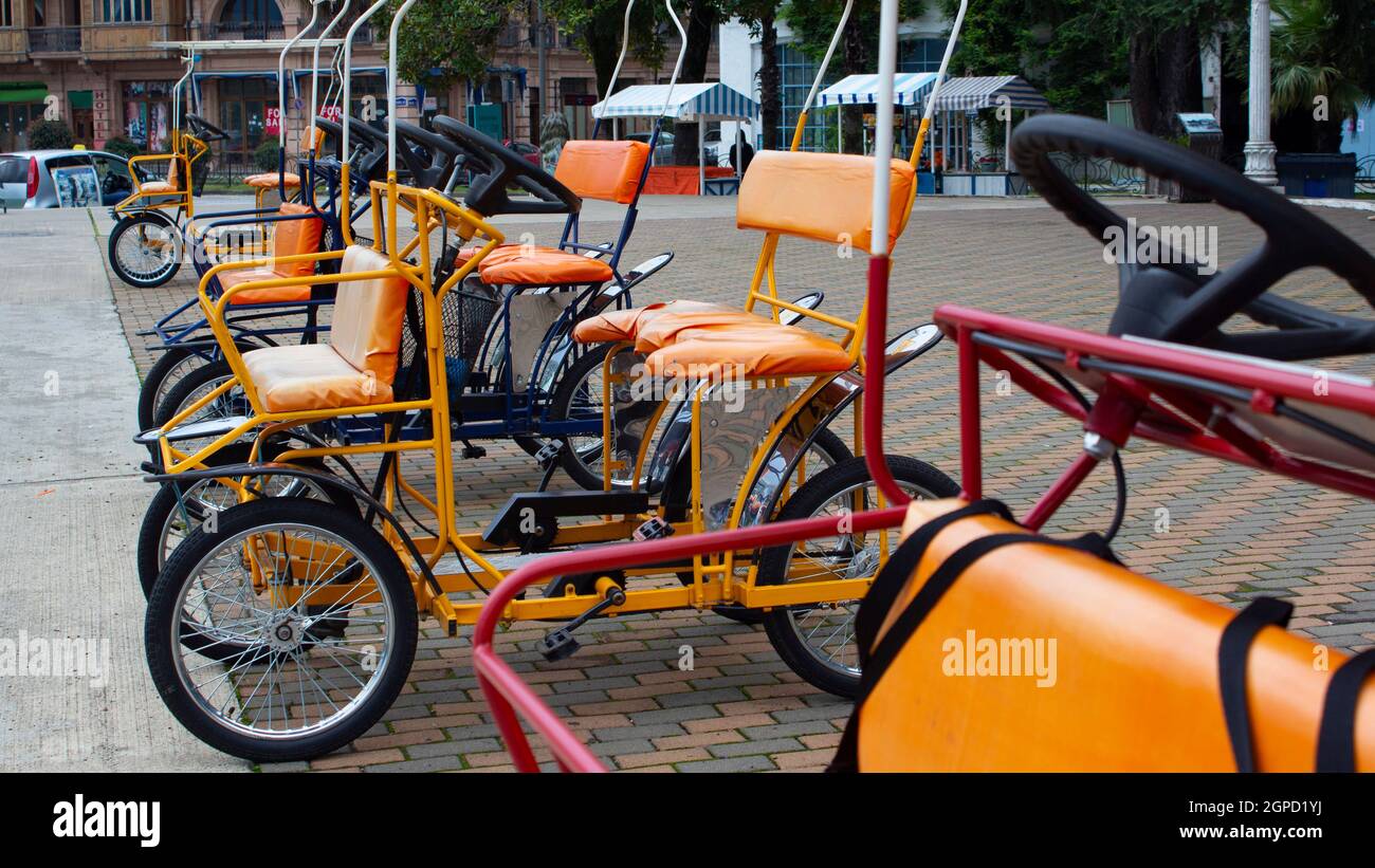 Empty orange cycle rickshaws stand on the street of the resort town ...