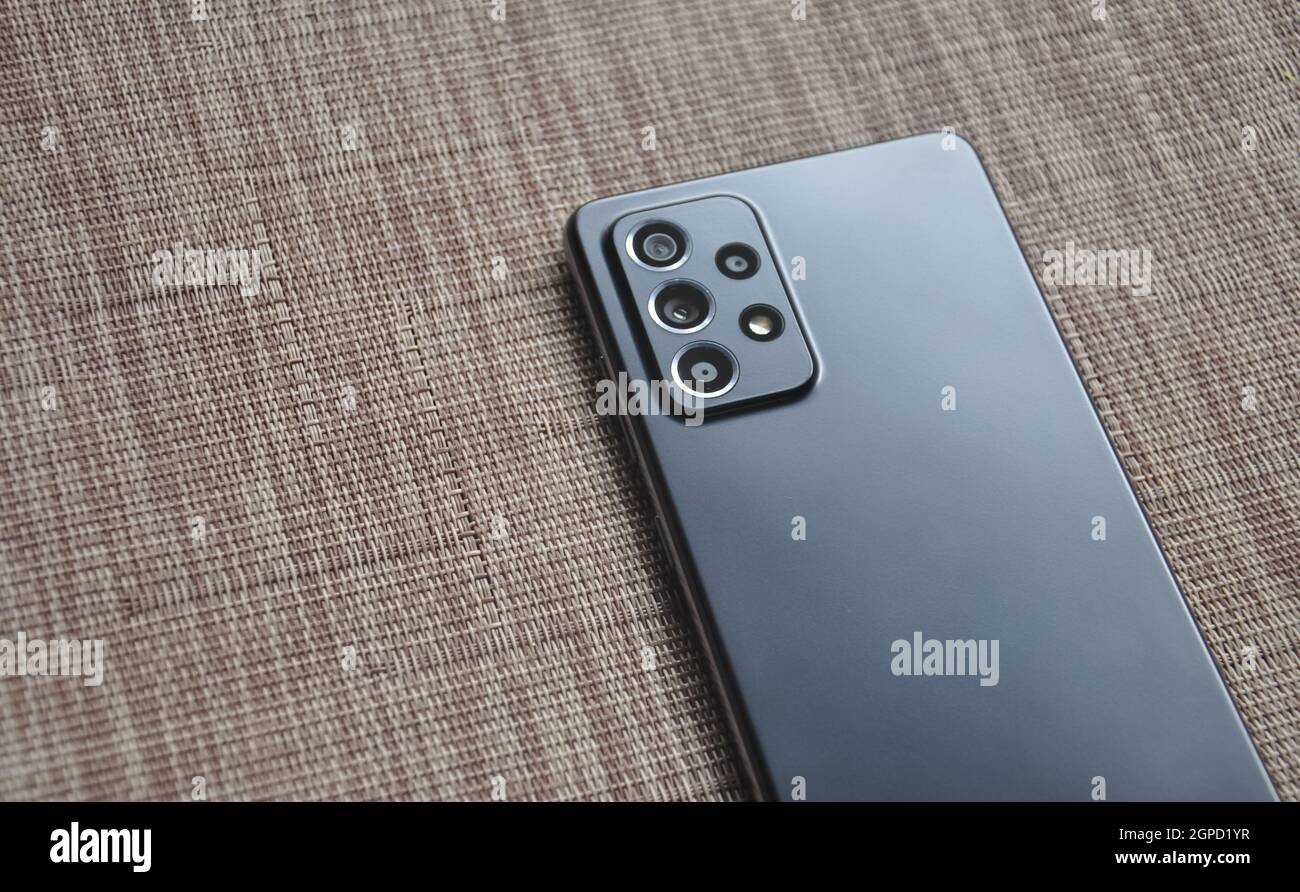 Back side of black color mobile phone (smartphone) over textured ...