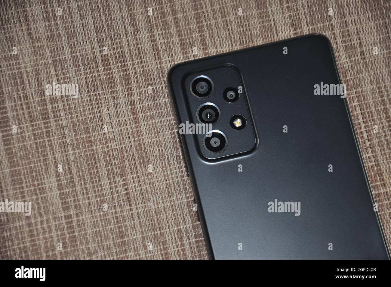 Back side of black color mobile phone (smartphone) over textured ...