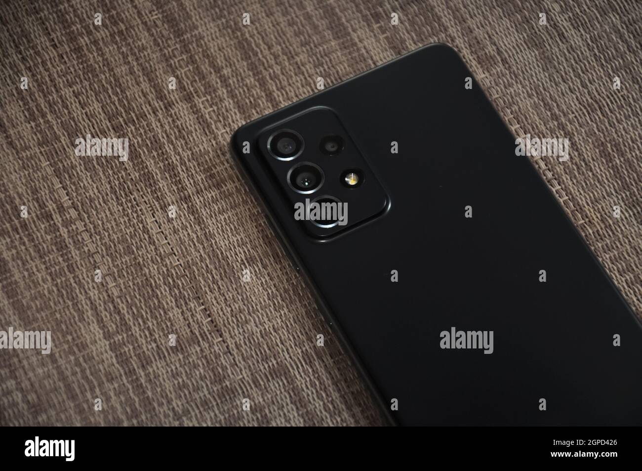 Back side of black color mobile phone (smartphone) over textured ...