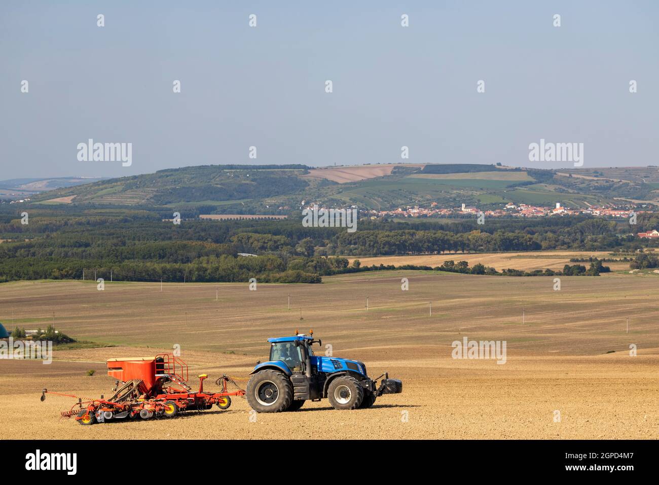 Tractor with seed drill in early spring landscape Stock Photo - Alamy