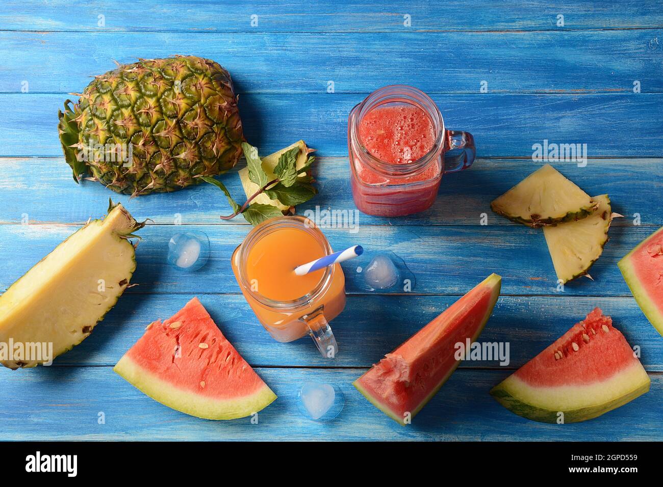 Fresh watermelon and pineapple cocktails in glasses on a blue rustic ...