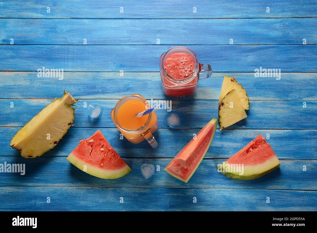 Fresh watermelon and pineapple cocktails in glasses on a blue rustic ...