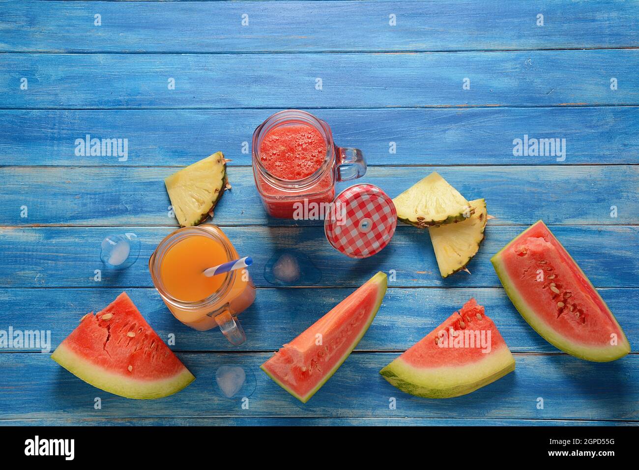 Fresh watermelon and pineapple cocktails in glasses on a blue rustic ...