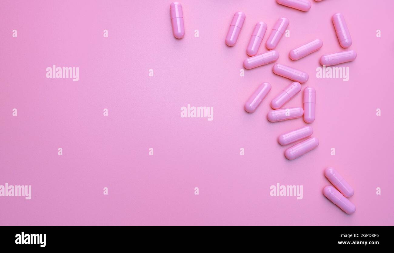 Pink antibiotic capsule pills spread on pink background. Antibiotic ...