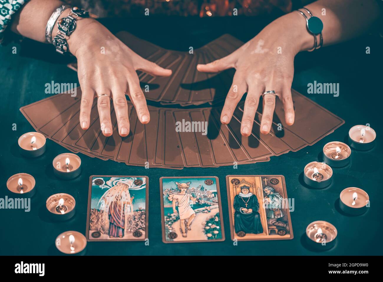 Fortune teller with tarot cards on table near burning candles.Tarot ...