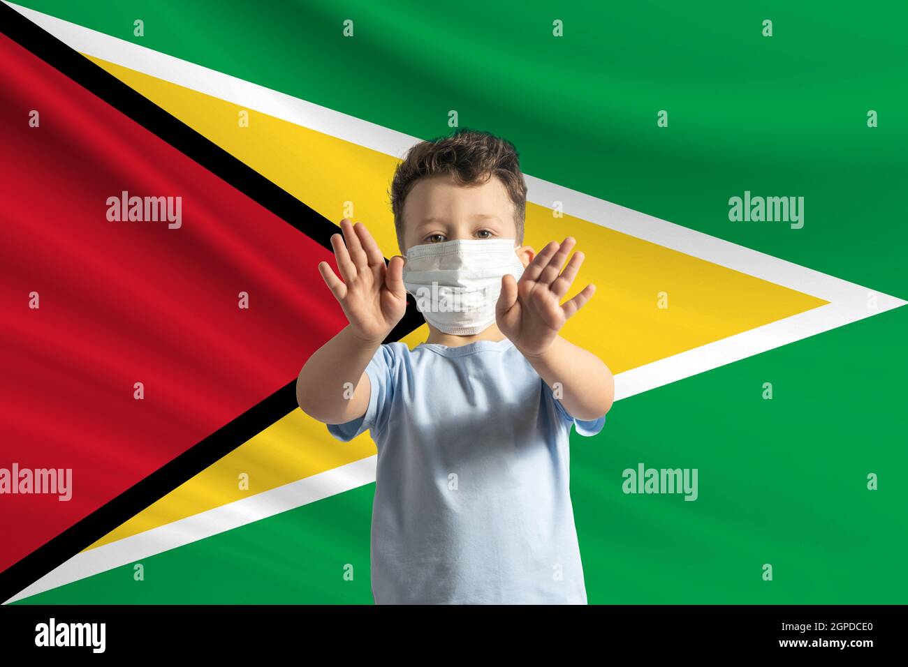 Little white boy in a protective mask on the background of the flag of ...