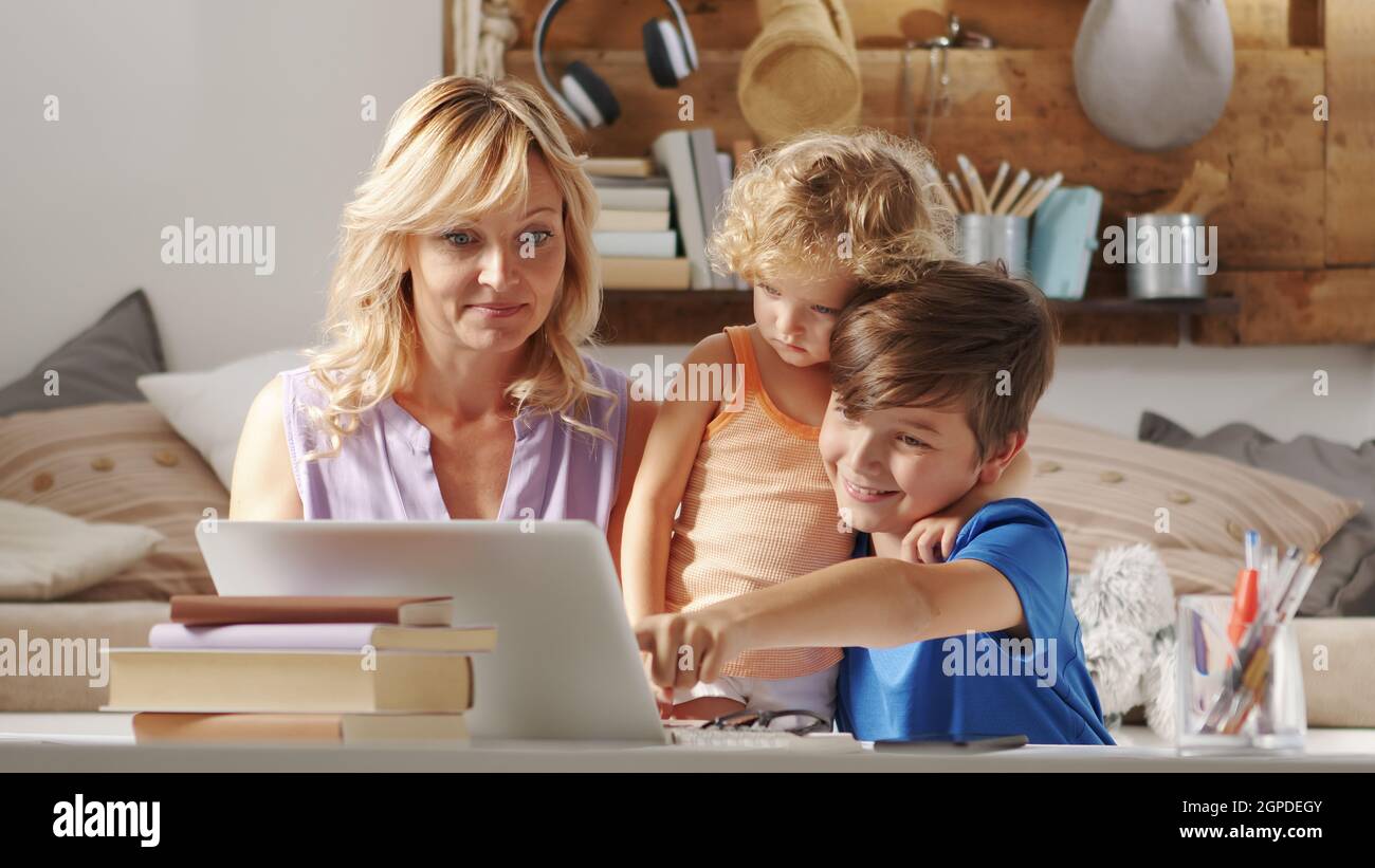 Happy family at home, mother with son and daughter have fun using ...