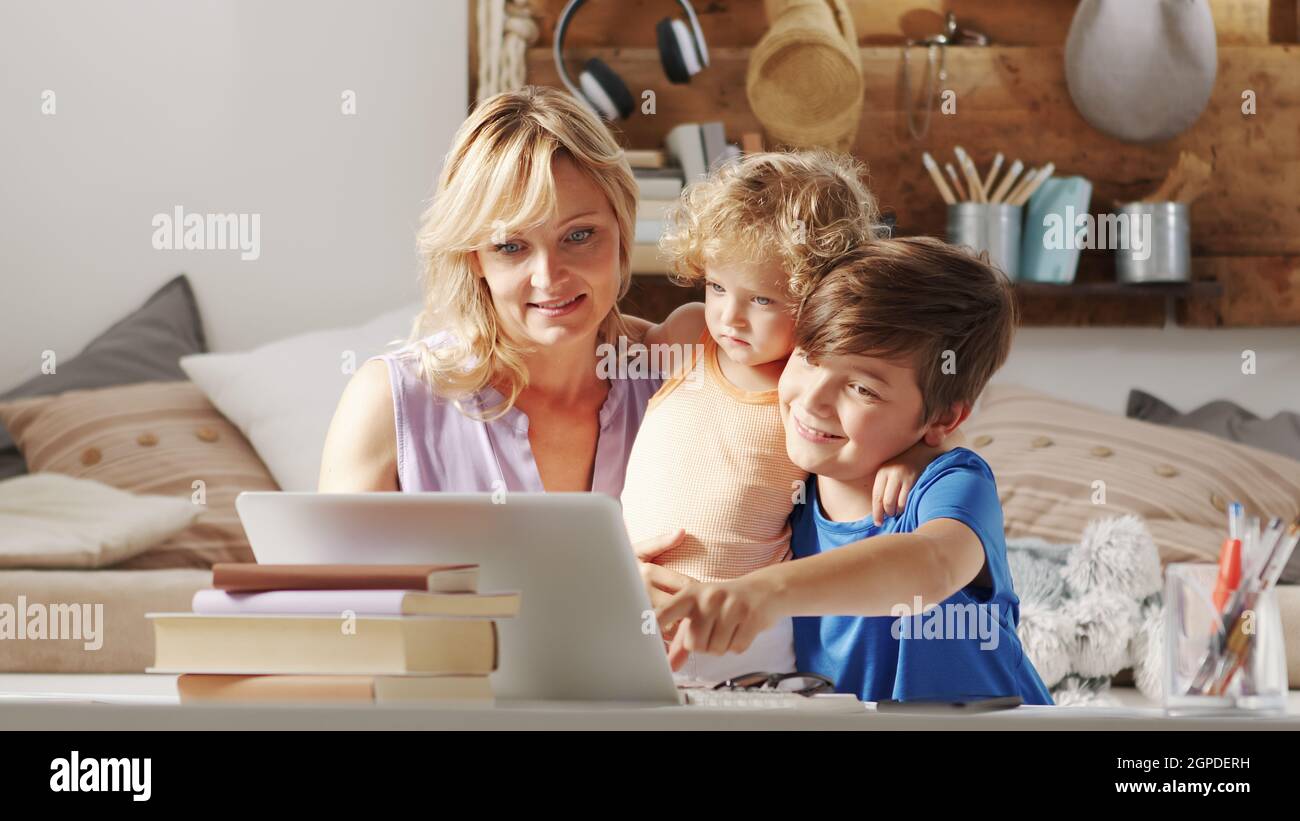 Happy family at home, mother with son and daughter have fun using ...