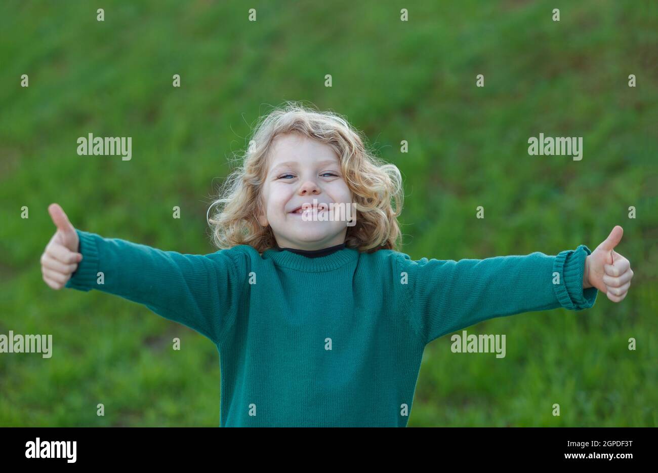 Adorable small blond child saying Ok in a park Stock Photo - Alamy