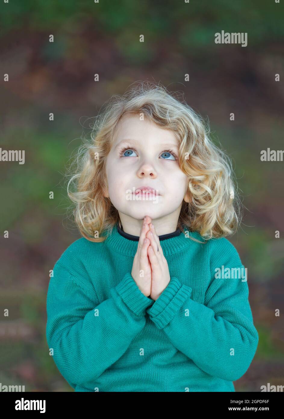 Beautiful child praying with his hands toguether Stock Photo - Alamy
