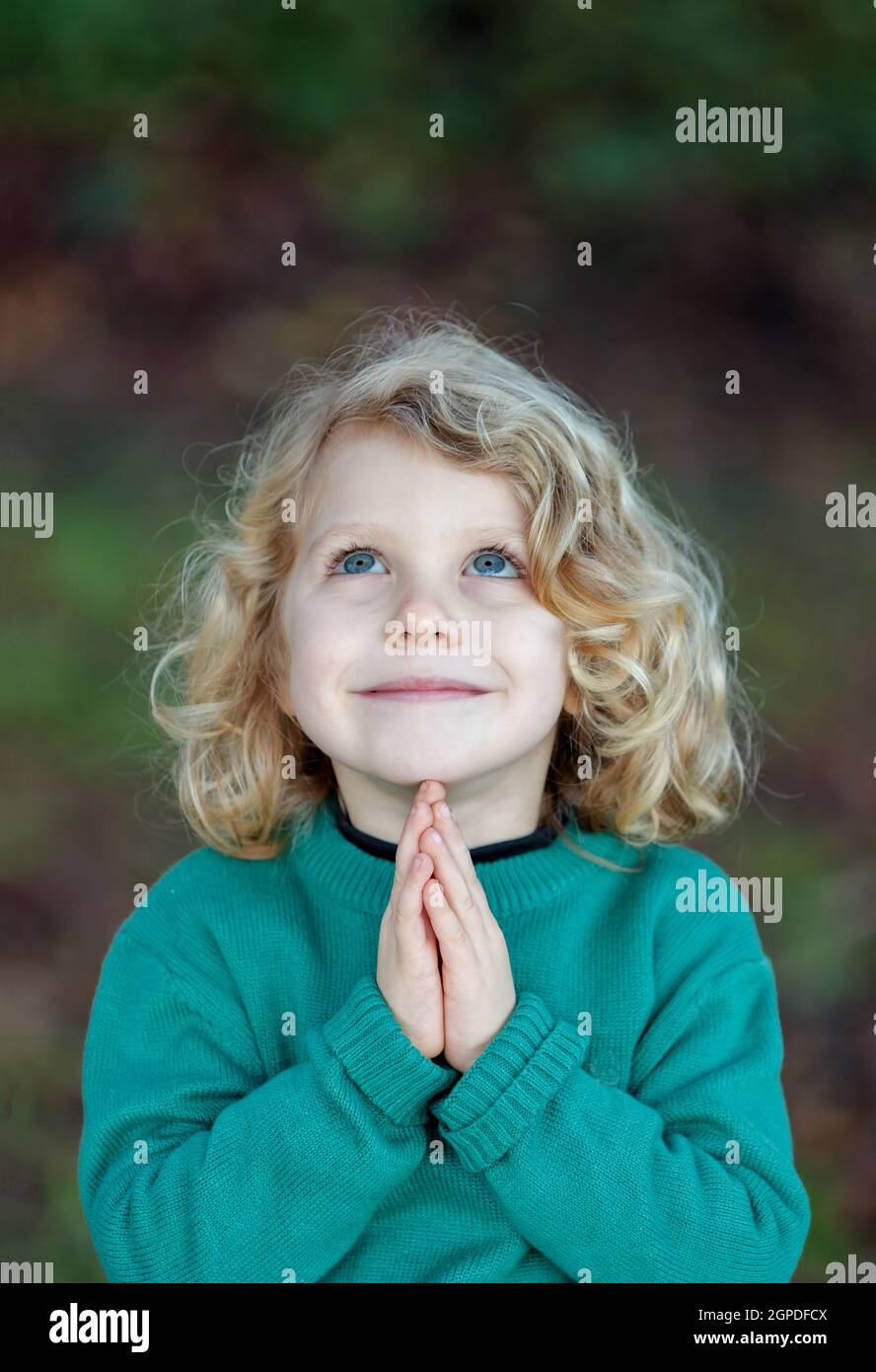 Beautiful child praying with his hands toguether Stock Photo - Alamy