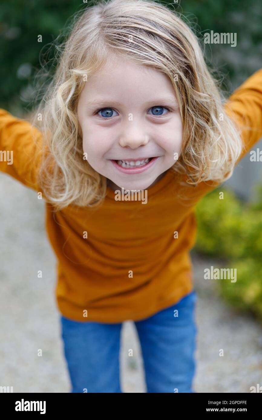 Happy child with red t-shirt playing in the garden Stock Photo - Alamy