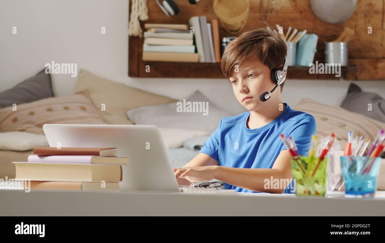 concentrated student boy studying on the computer at remote school on ...