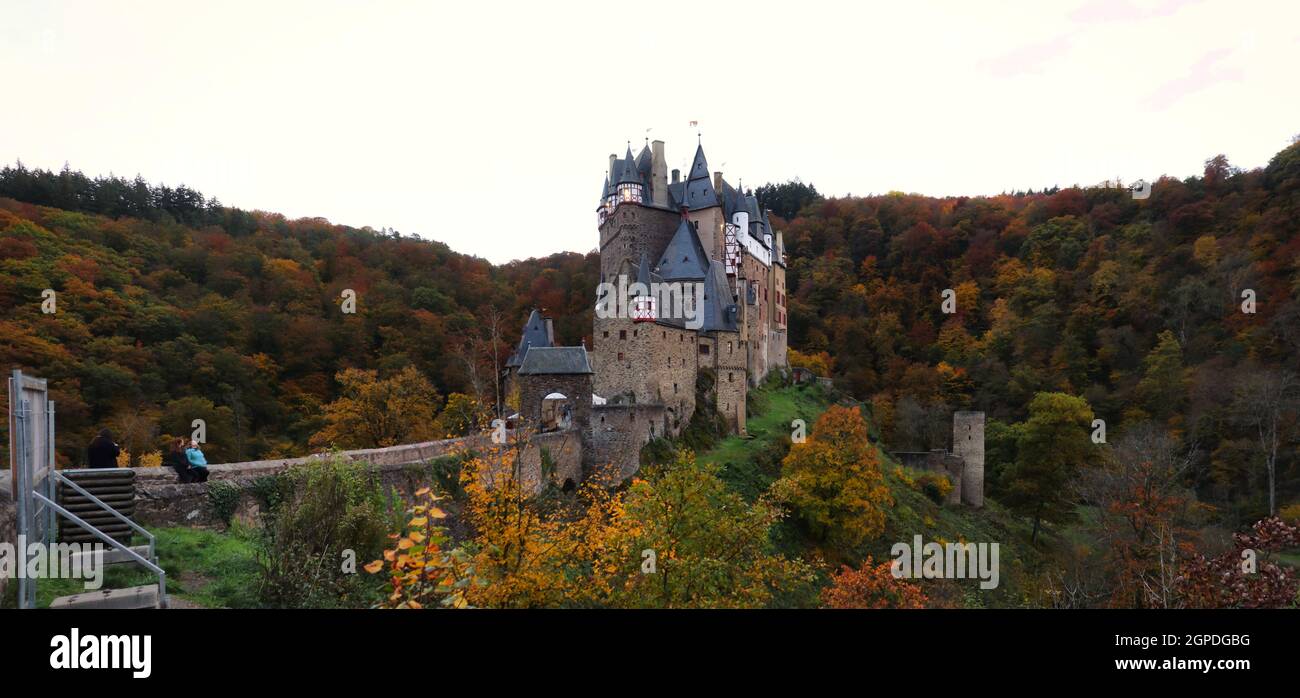 Eltz Castle and surrounding hills covered in colorful fall foliage pano ...
