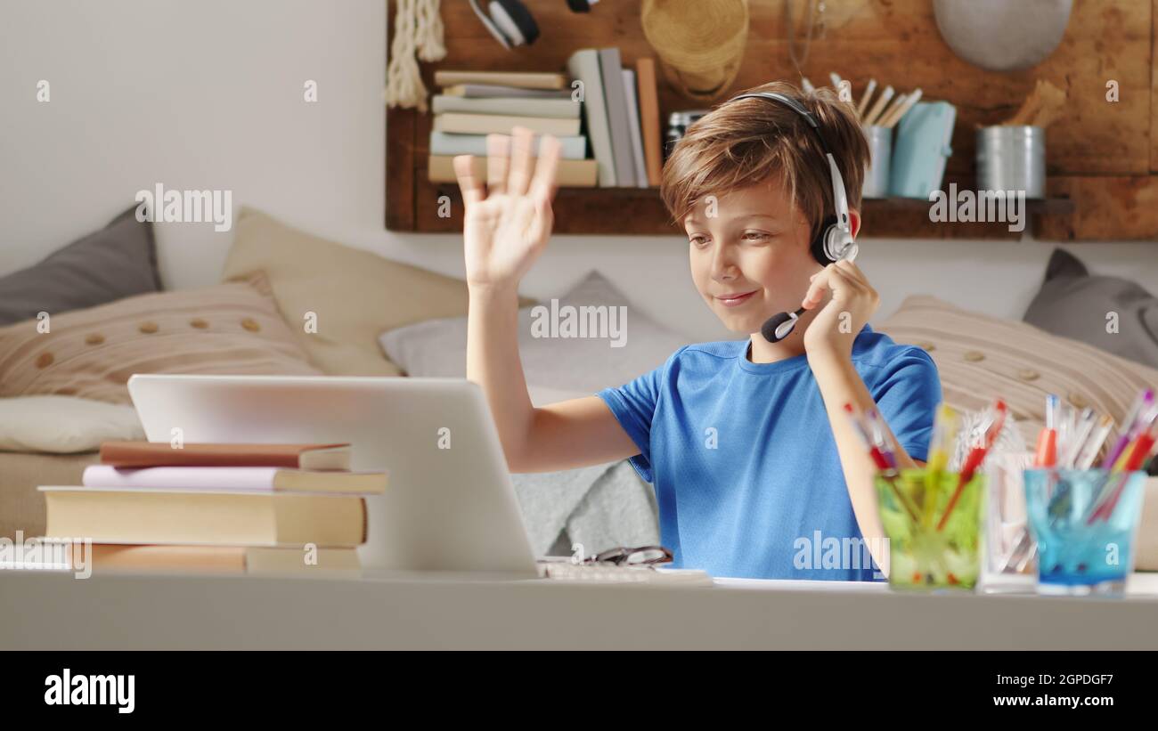 smiling student boy studying at home with remote school connected to ...