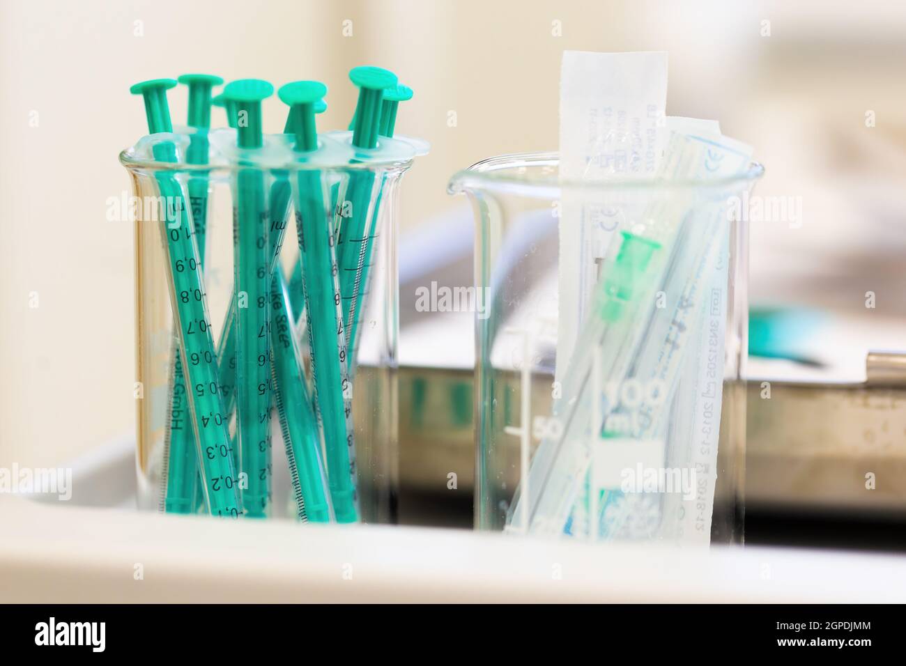 Two measuring cups filled with injections in laboratory. Bunch of ...