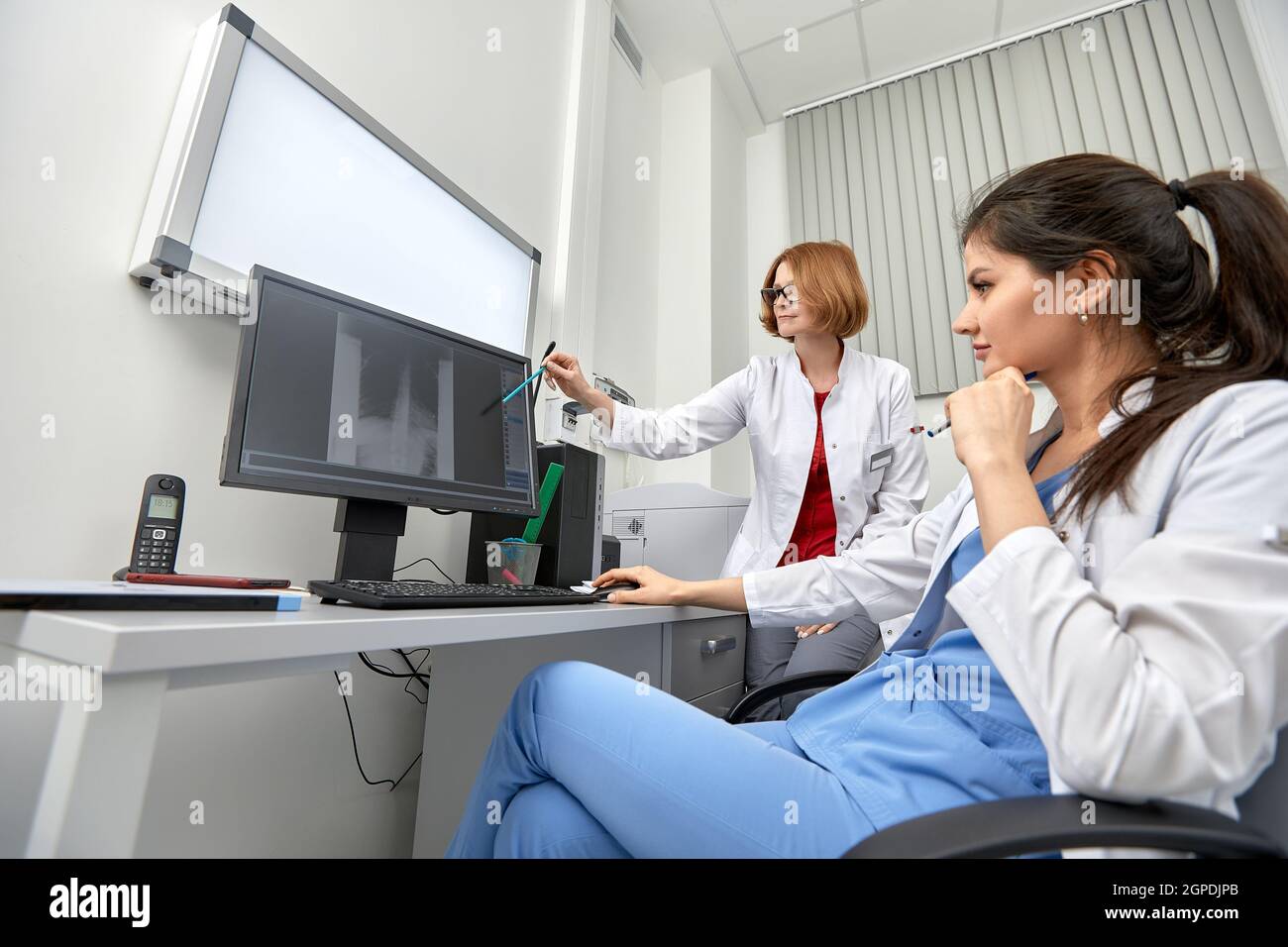 medical team discussing around a computer Stock Photo - Alamy