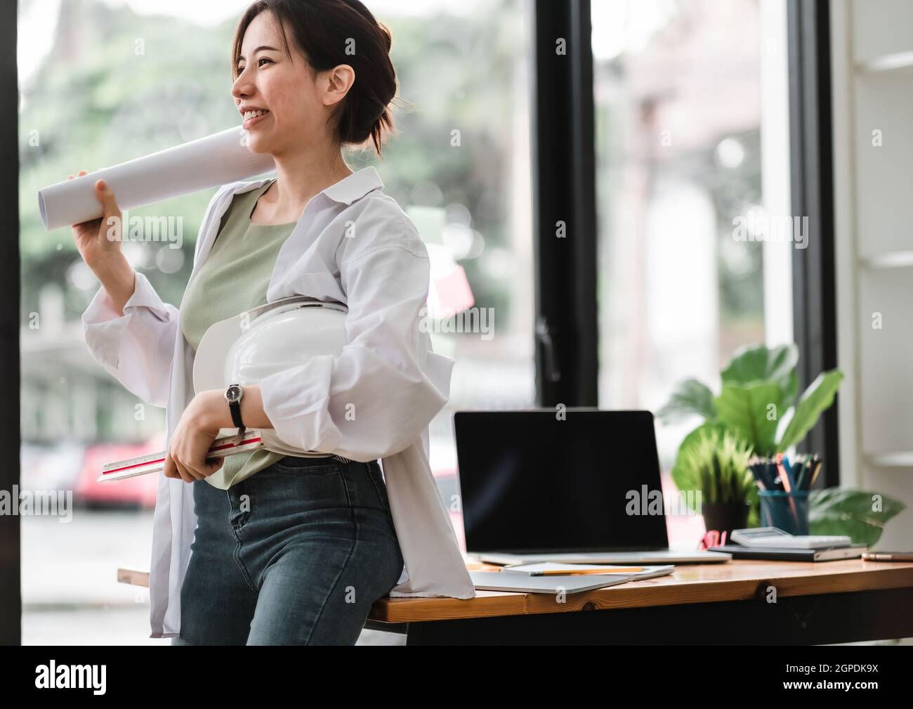 Portrait asian engineering woman standing with blueprint and safety ...