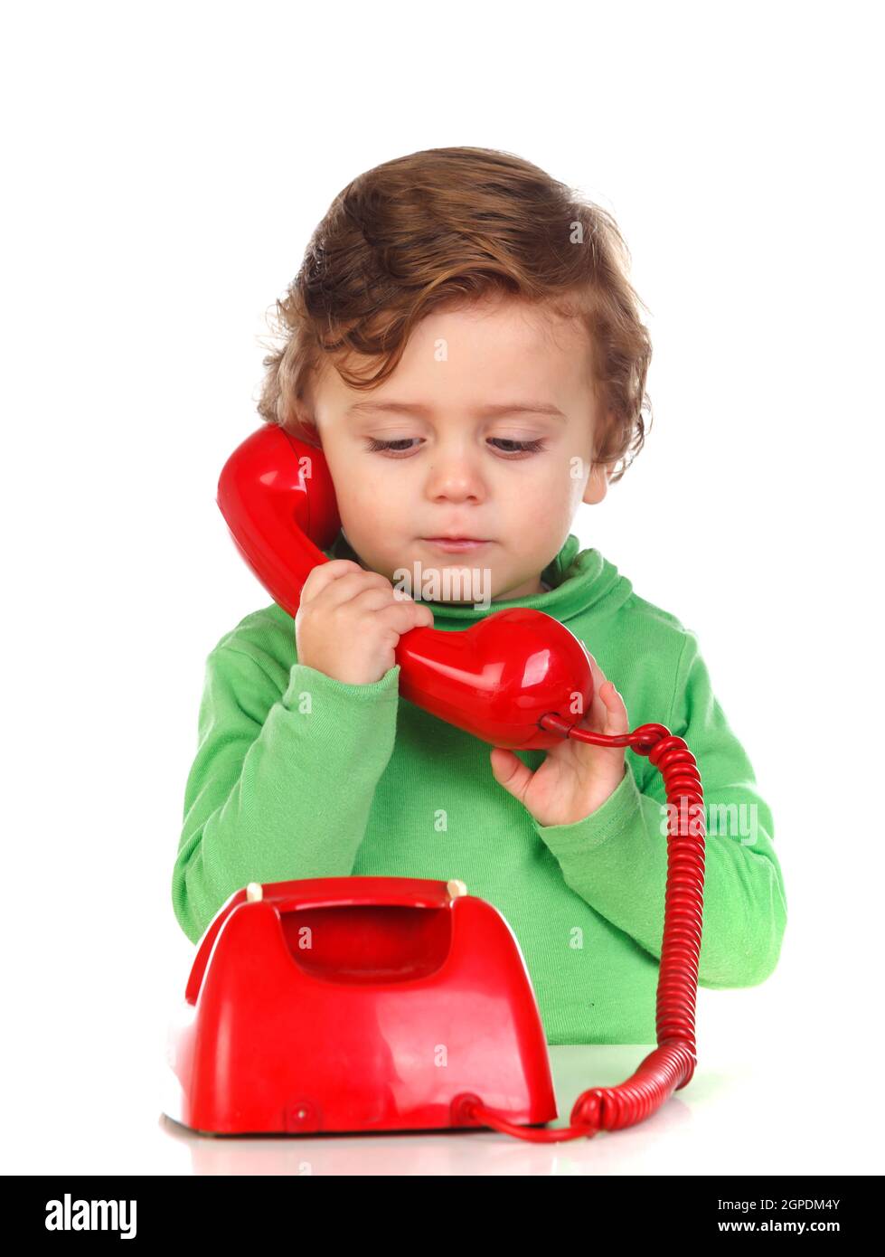 Baby with one years old playing with a red phone isolated on a white ...