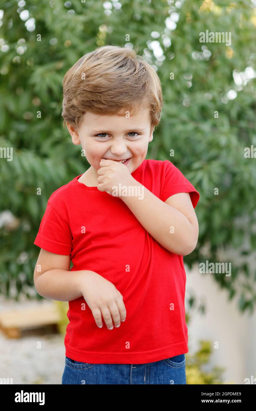 Happy child with red t-shirt playing in the garden Stock Photo - Alamy