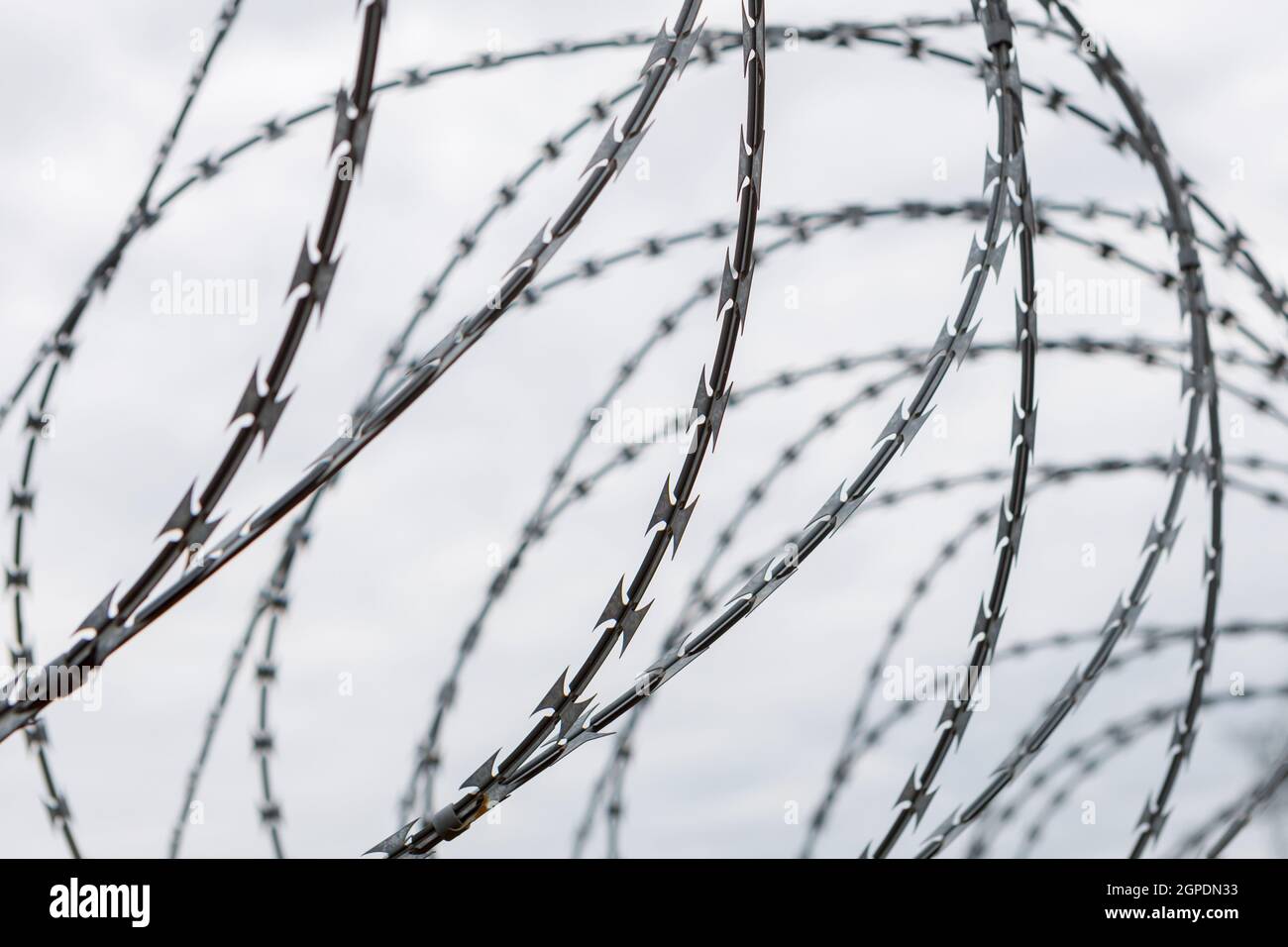 Fence with a barbed wire under a blue sky Stock Photo - Alamy