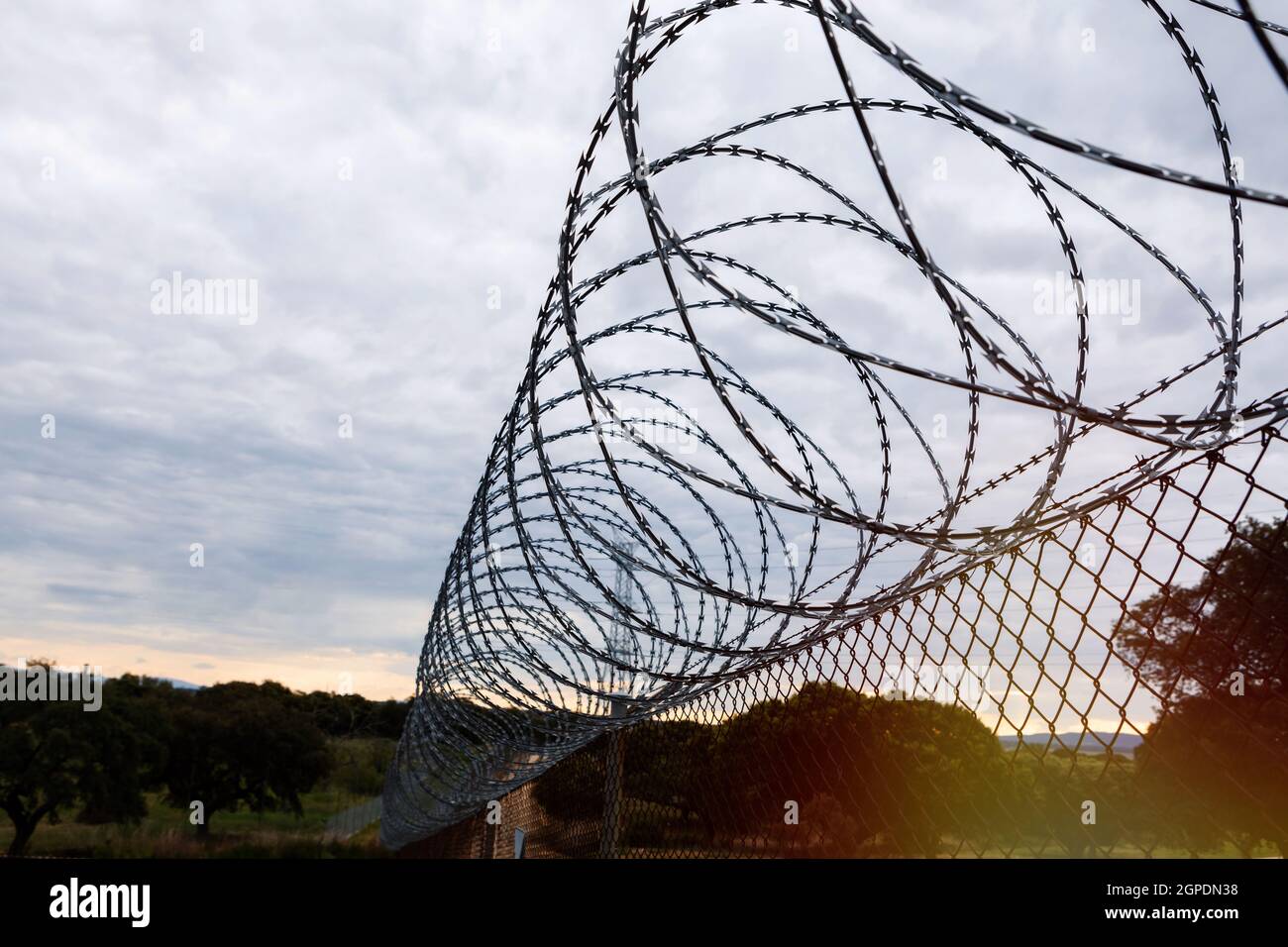 Fence with a barbed wire under a blue sky Stock Photo - Alamy