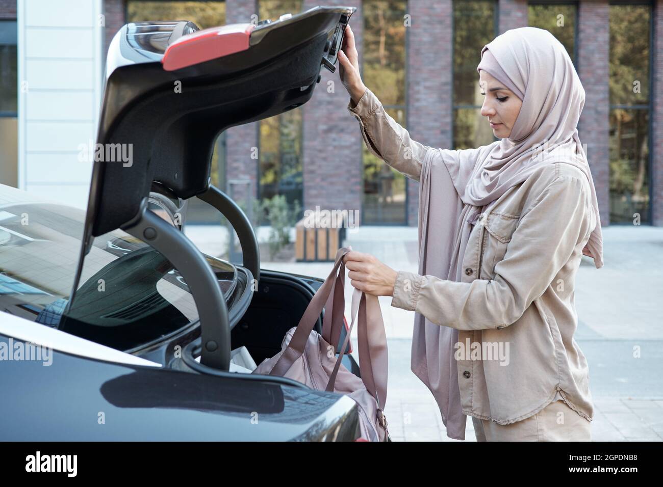 Horizontal medium side view shot of modern muslim woman sanding ...