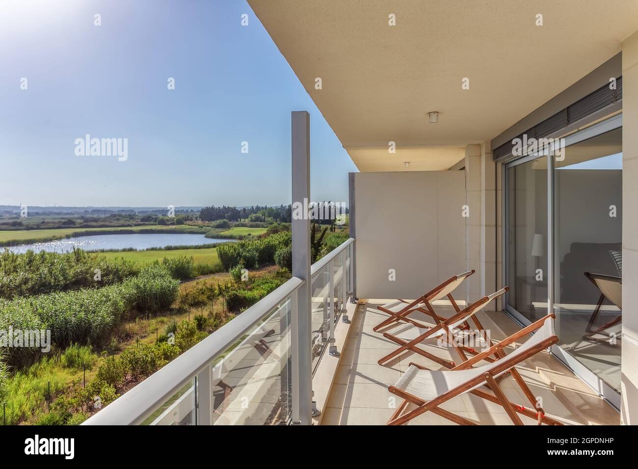 Balcony terrace, overlooking the lake and park, with wooden deck chairs ...