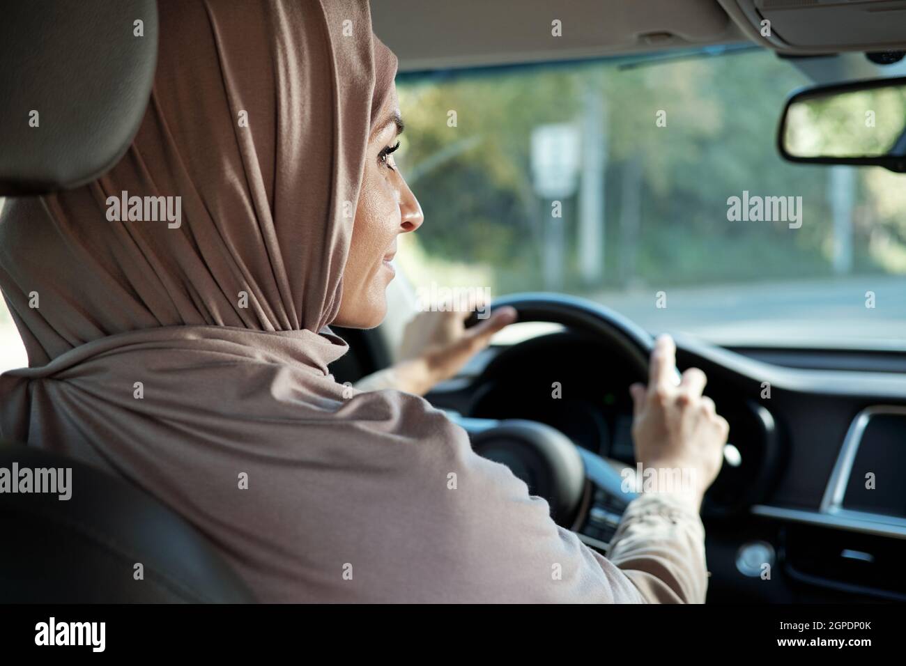Horizontal rear view portrait shot of modern Muslim woman wearing hijab ...