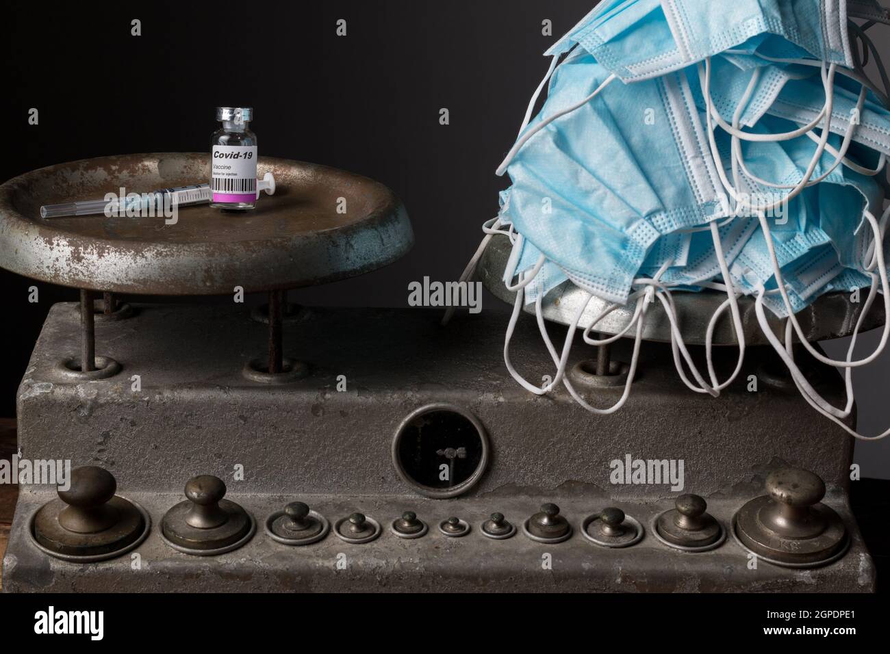 Covid-19 vaccine vial and face masks on scales Stock Photo - Alamy