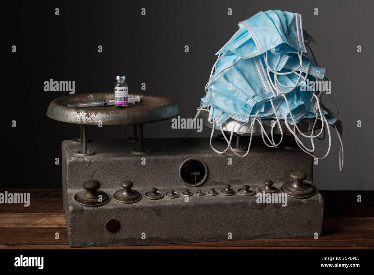 Covid-19 vaccine vial and face masks on scales Stock Photo - Alamy