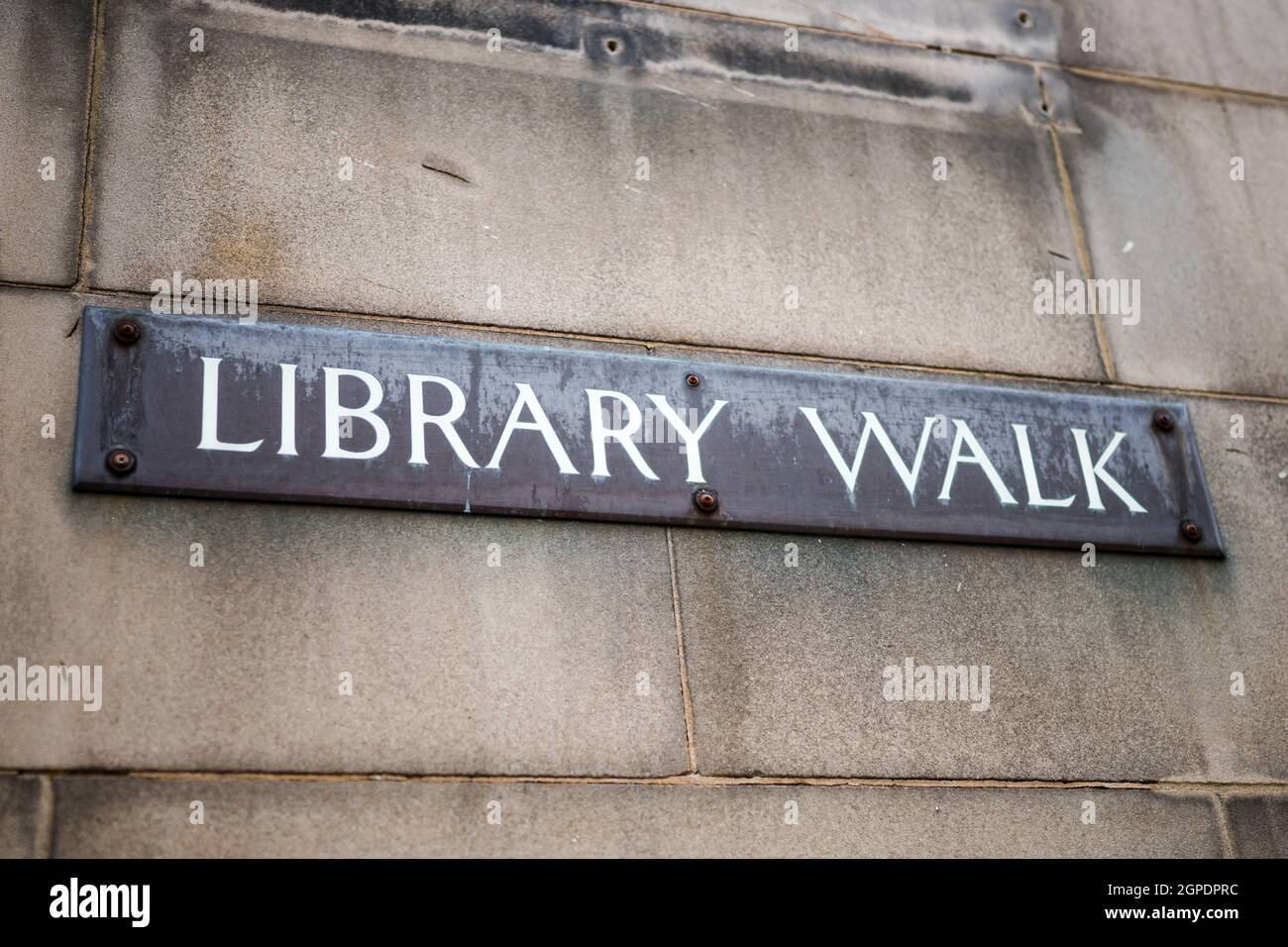 Library Walk sign on old stone wall. Metal sign with white text Stock ...