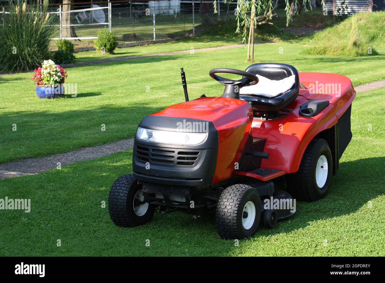 Red riding mower on the grass outdoors during the daylight Stock Photo ...