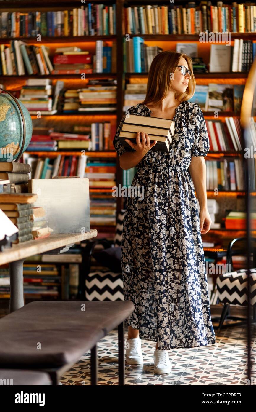 Back to school library concept. Student girl holding book on her hands ...