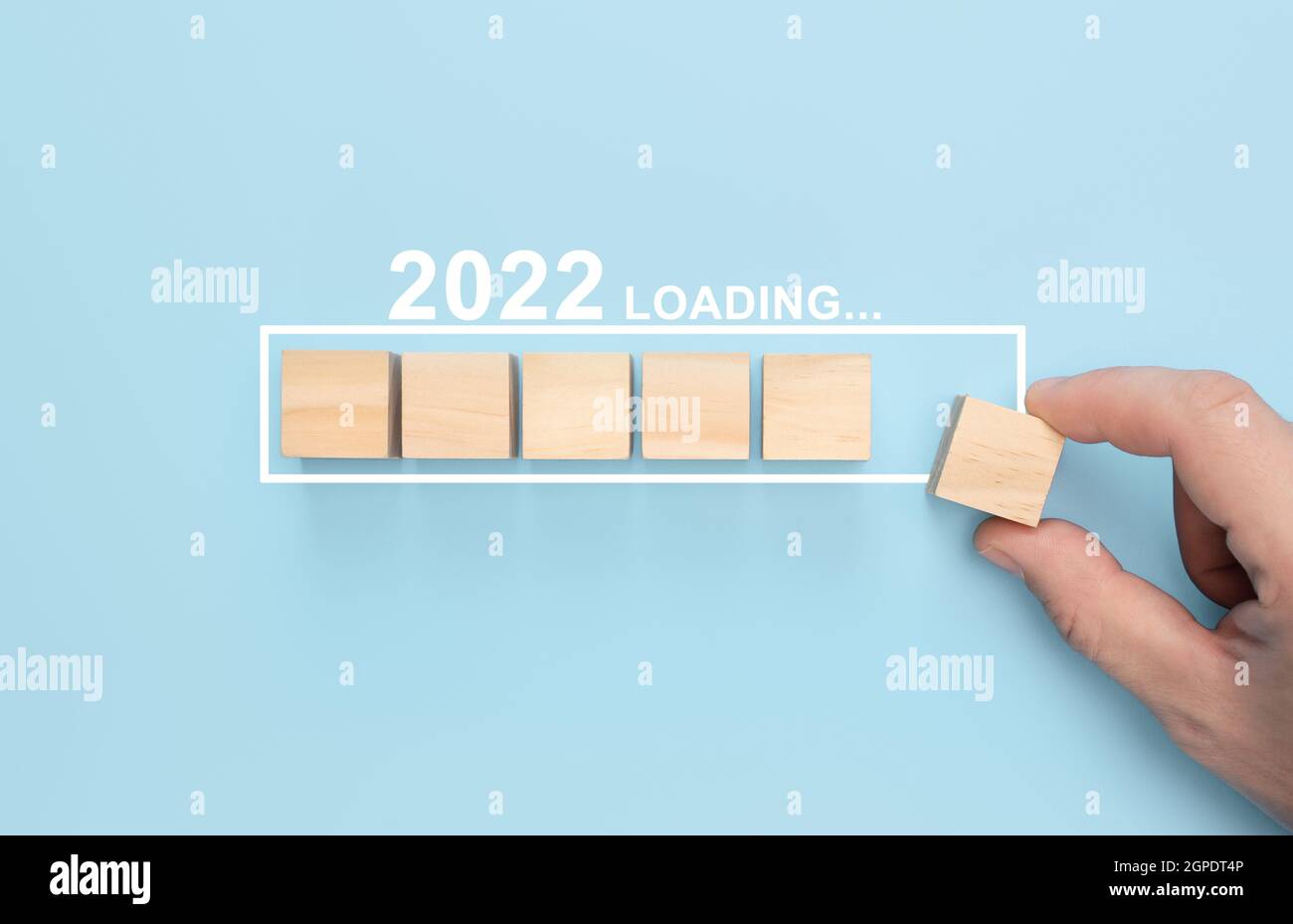 Loading new year 2022 with hand putting wood cube in progress bar ...