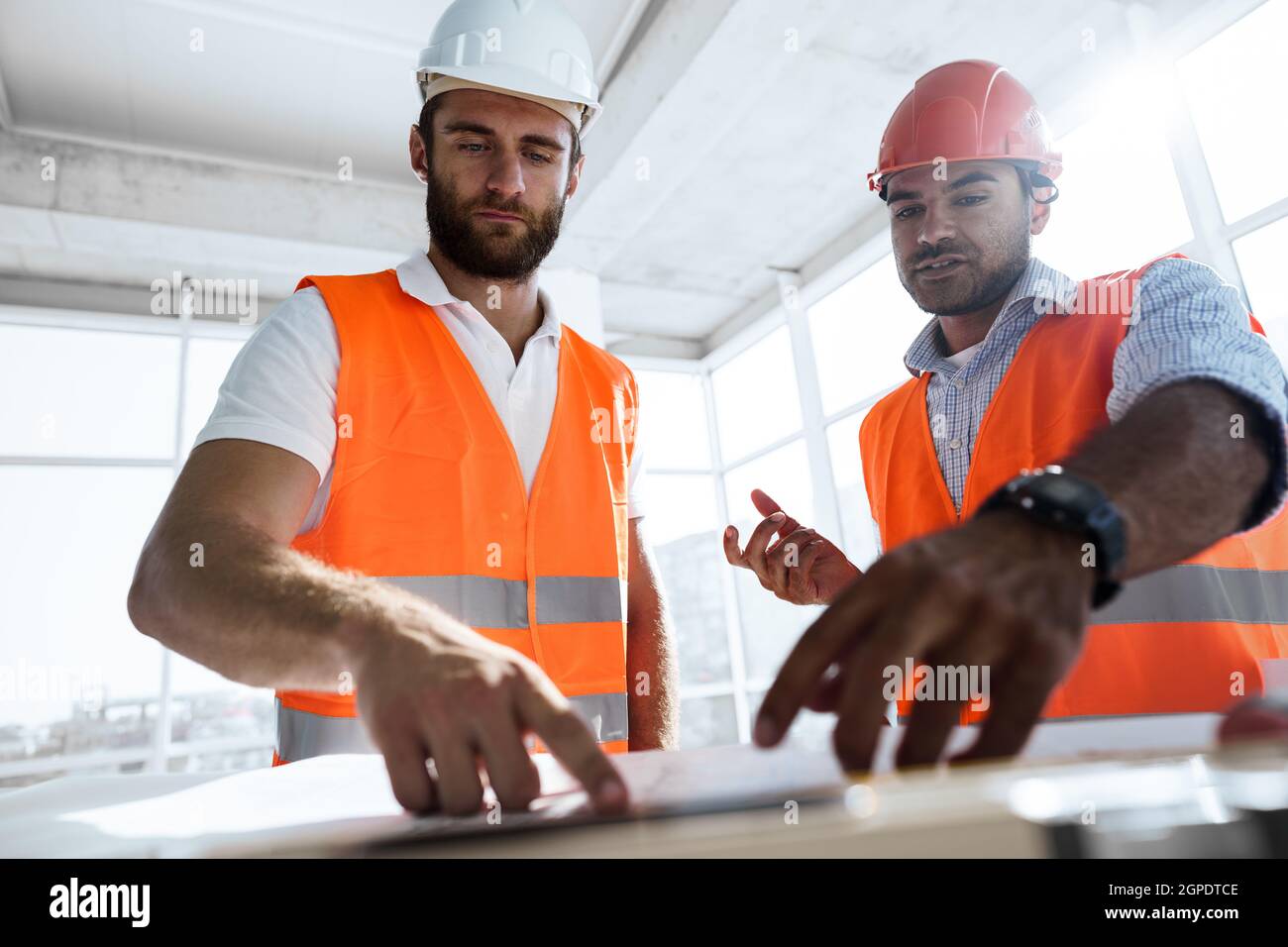 Two engineers man looking at project plan on the table in construction ...