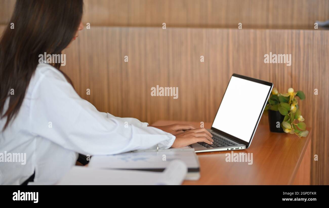 Asian young businesswoman or assistant typing on laptop keyboard ...