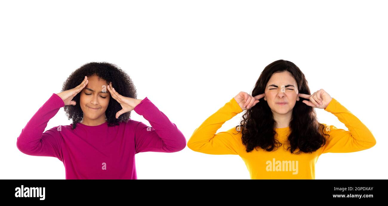 Two annoyed teenager girls covering her ears isolated on a white ...